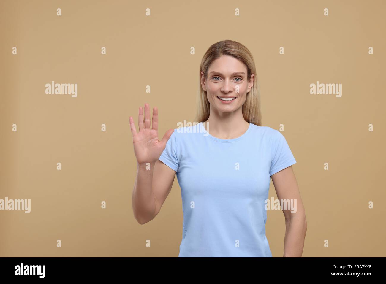 Woman giving high five on light brown background Stock Photo - Alamy