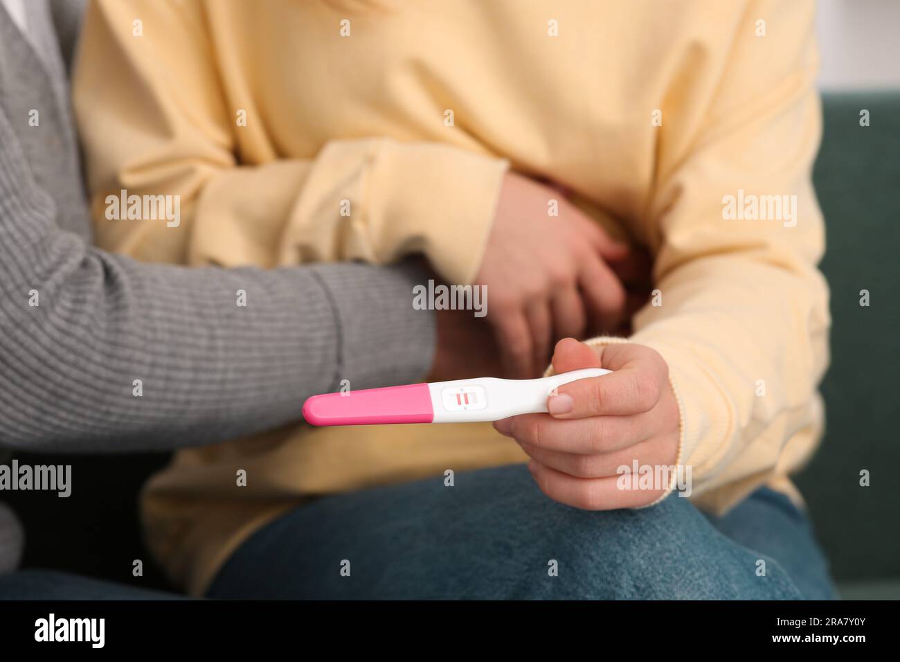 Young woman showing her mother pregnancy test, closeup. Grandparent ...