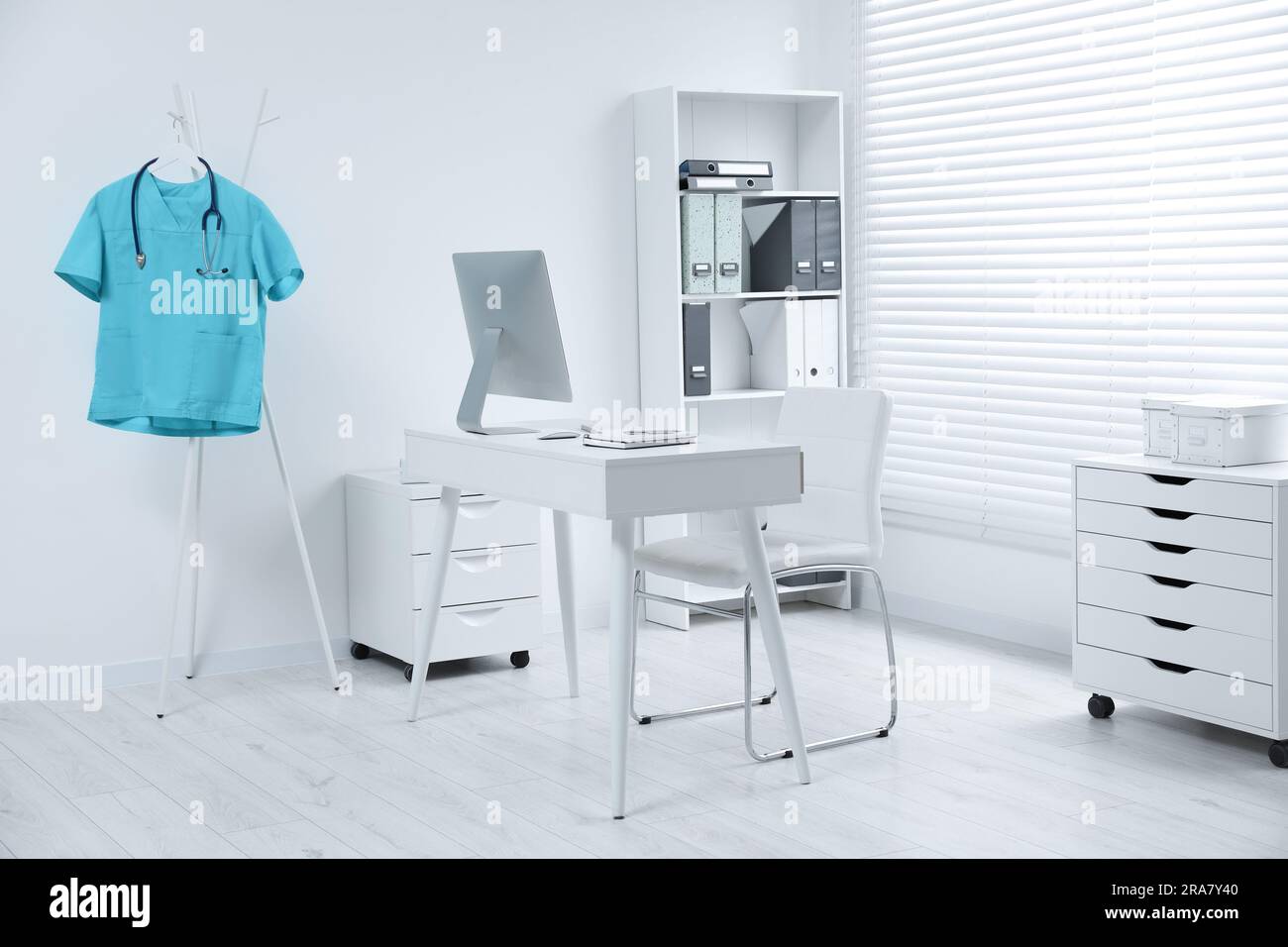 Turquoise medical uniform and stethoscope hanging on rack in clinic ...