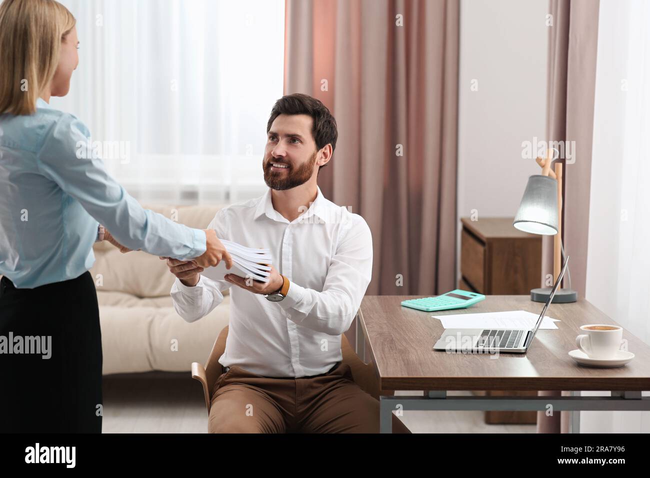 Woman giving documents to colleague in office Stock Photo - Alamy