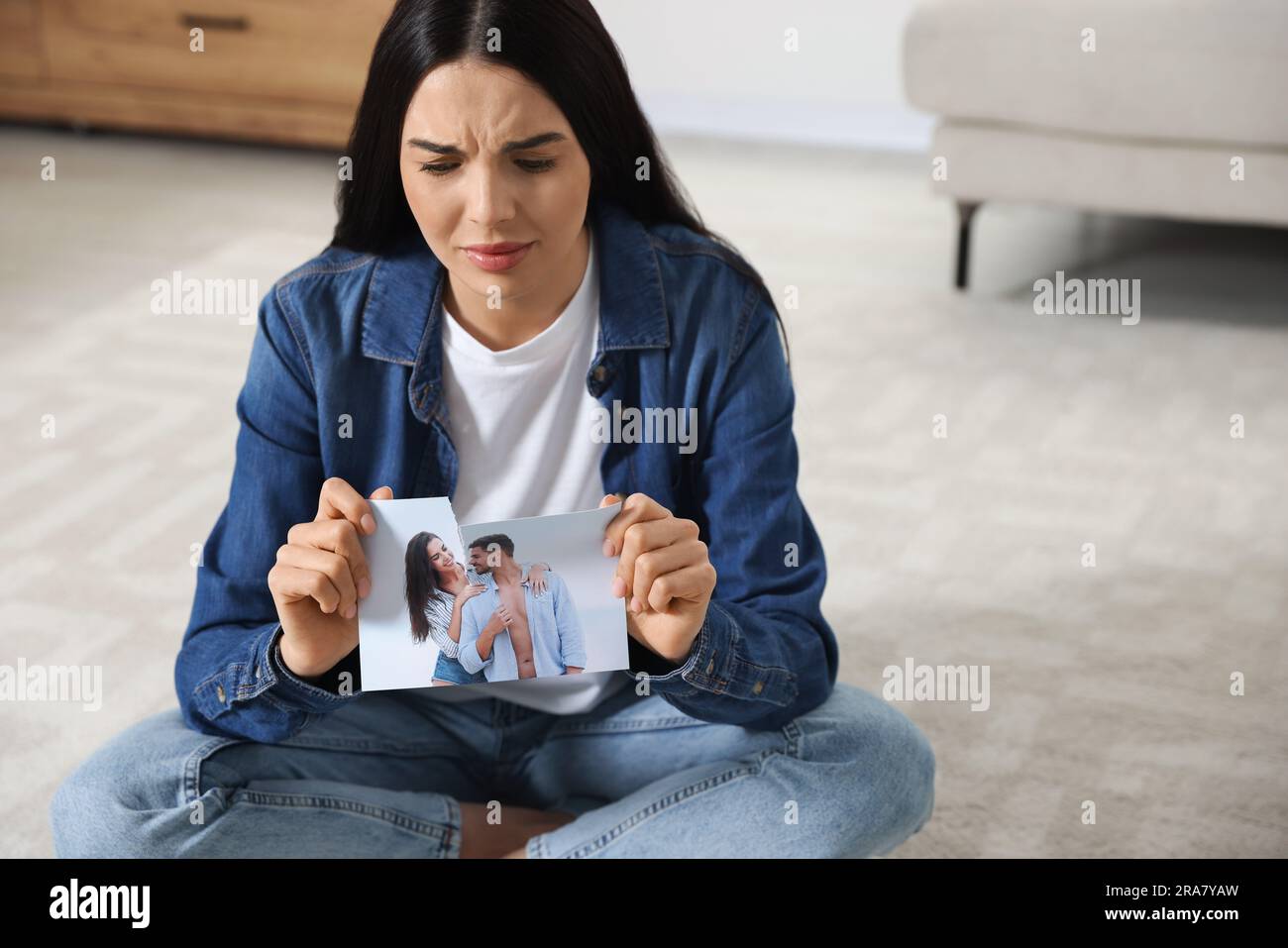 Upset woman ripping photo at home. Divorce concept Stock Photo - Alamy
