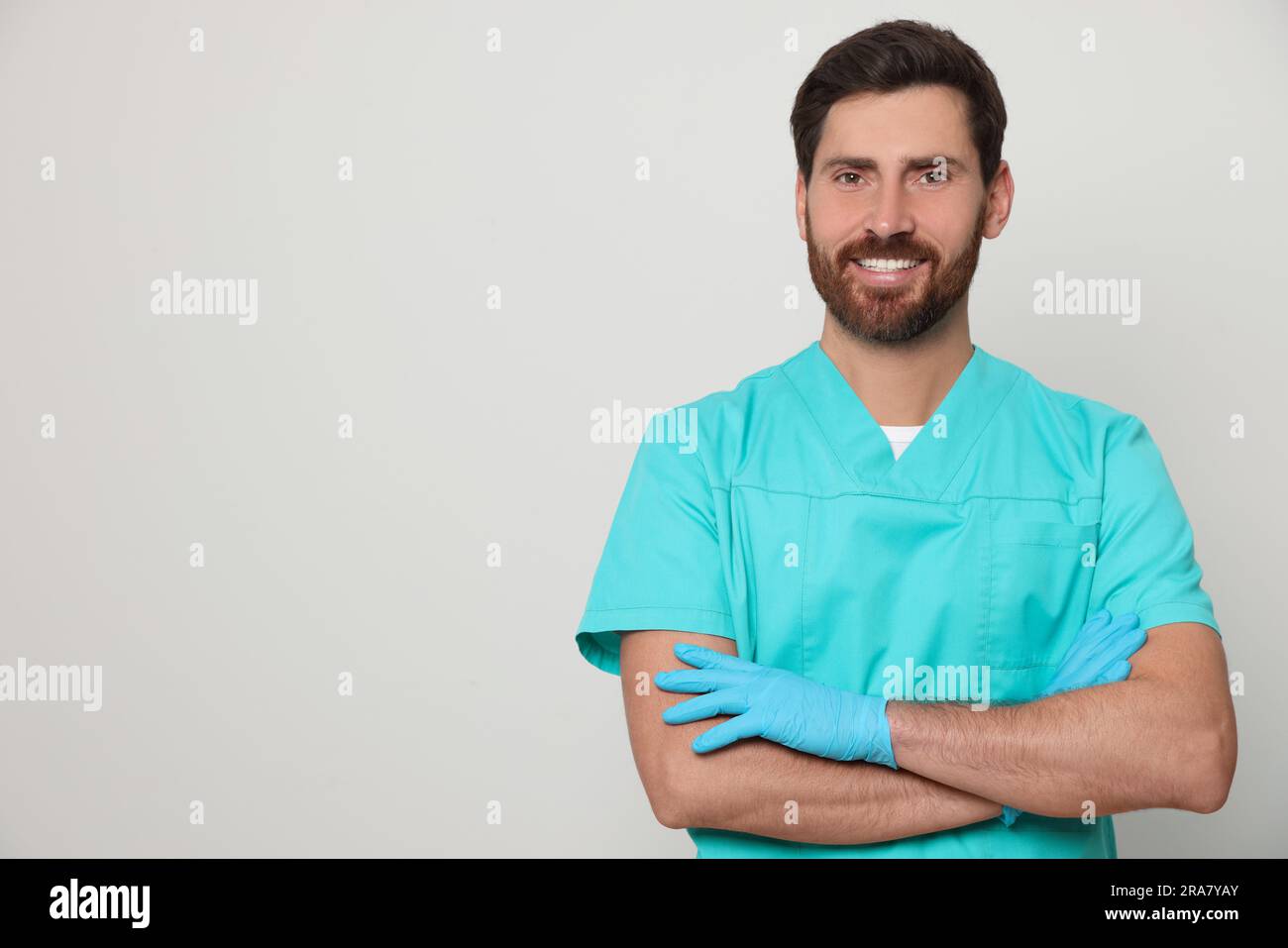 Happy nurse in medical uniform on white background, space for text ...