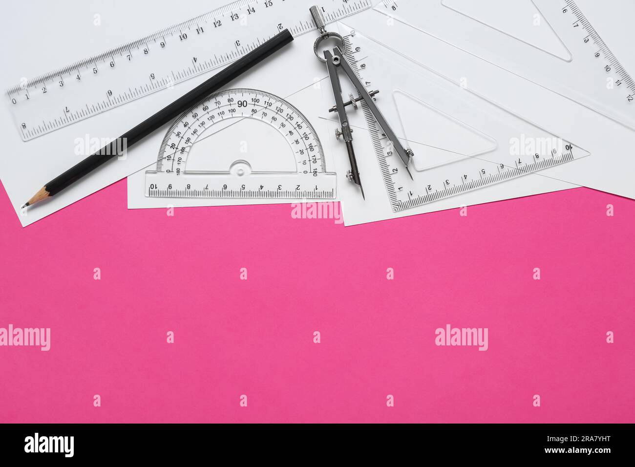 Different rulers, pencil and compass on pink background, flat lay ...