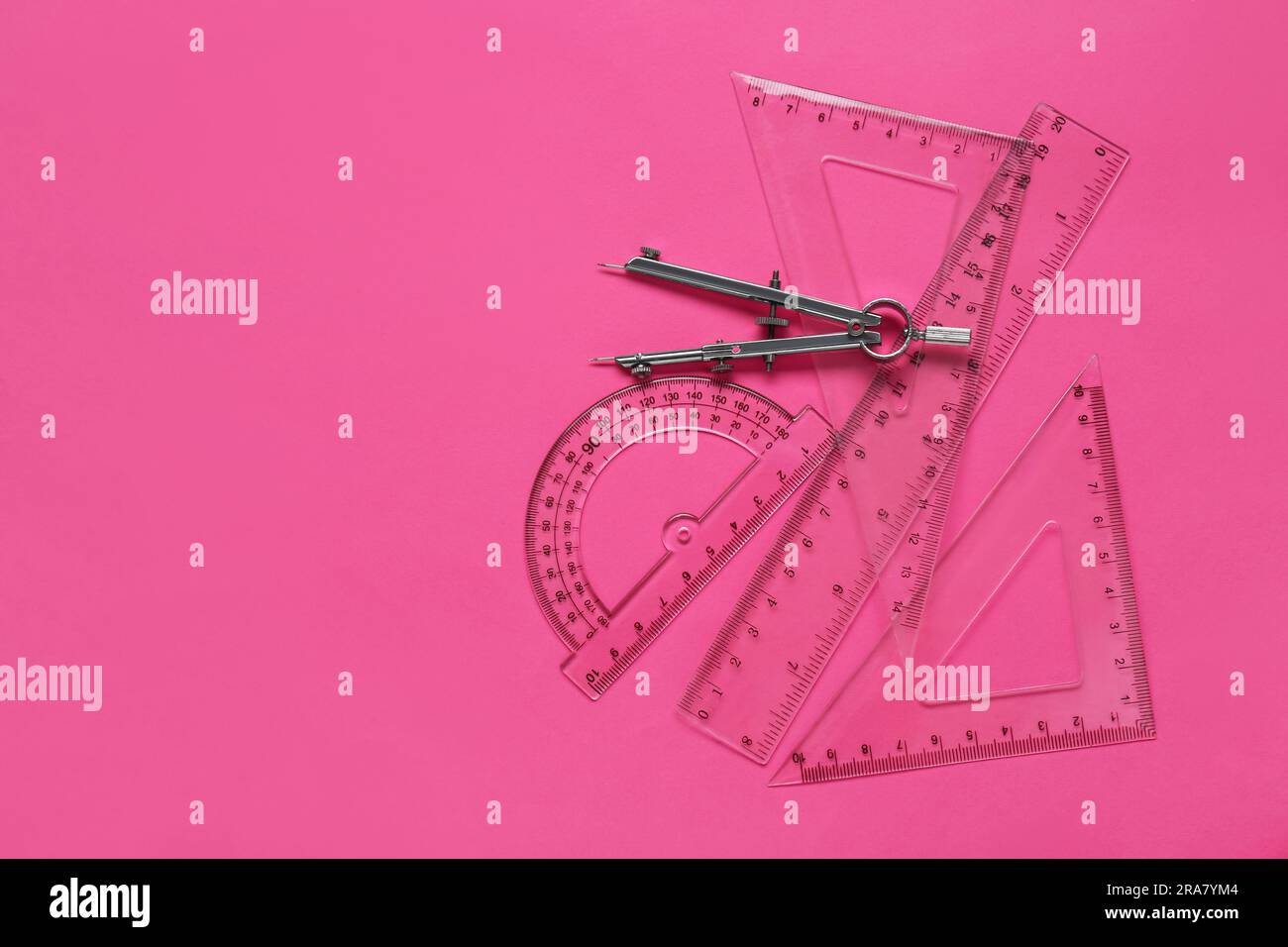 Flat lay composition with different rulers and compass on pink ...