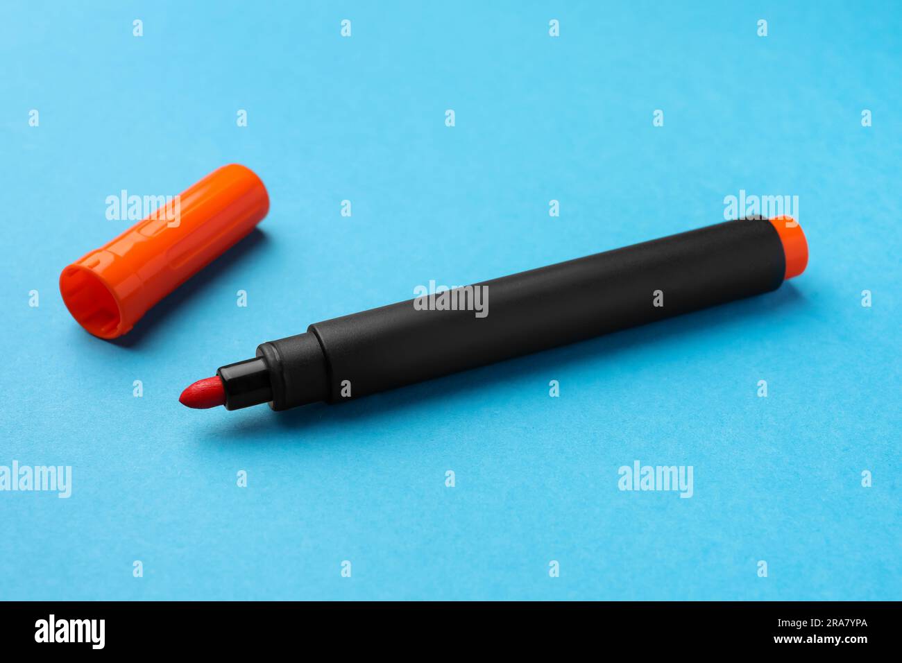 Bright orange marker on light blue background Stock Photo - Alamy
