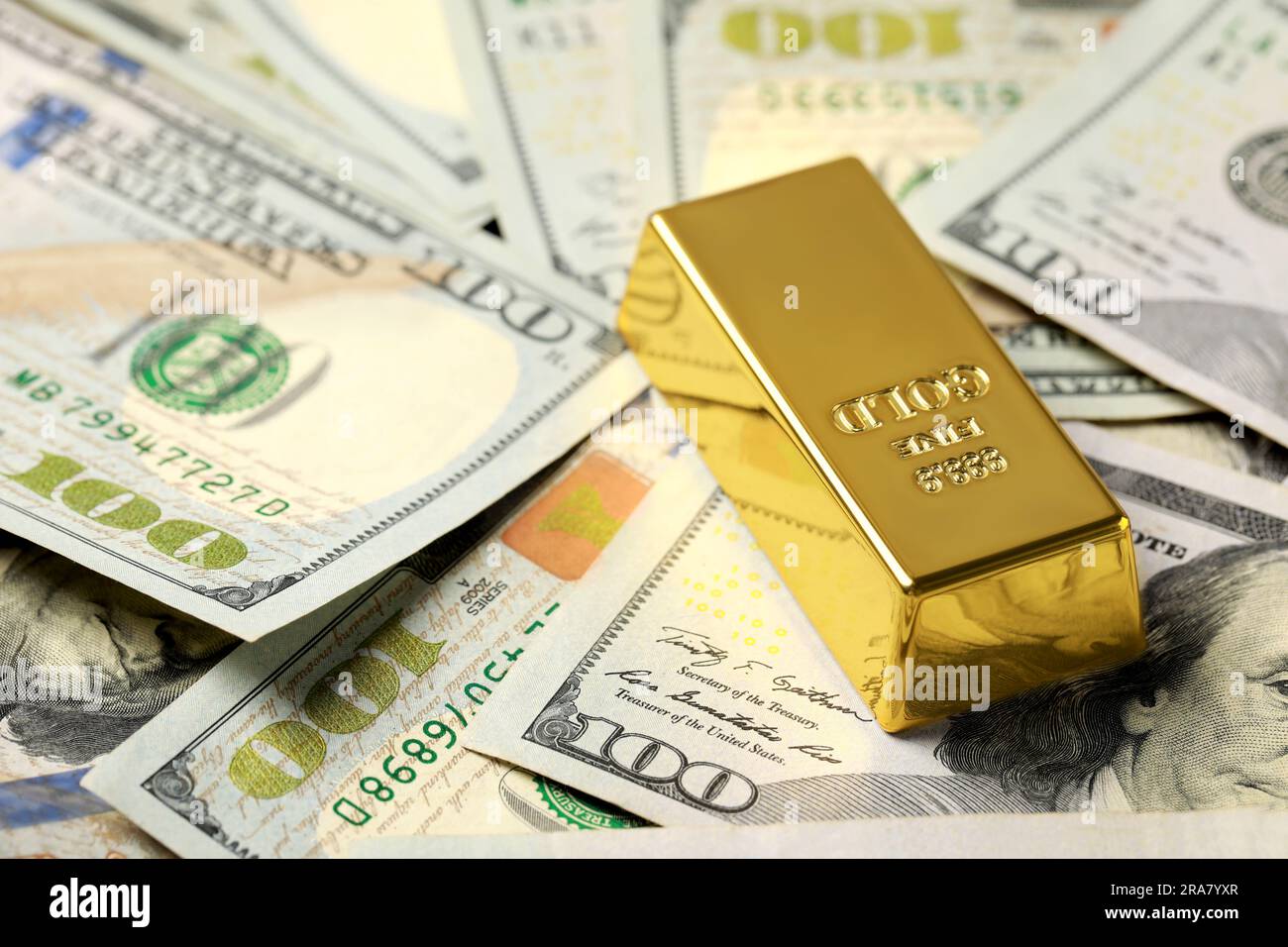 Shiny gold bar on dollar banknotes, closeup. Space for text Stock Photo ...