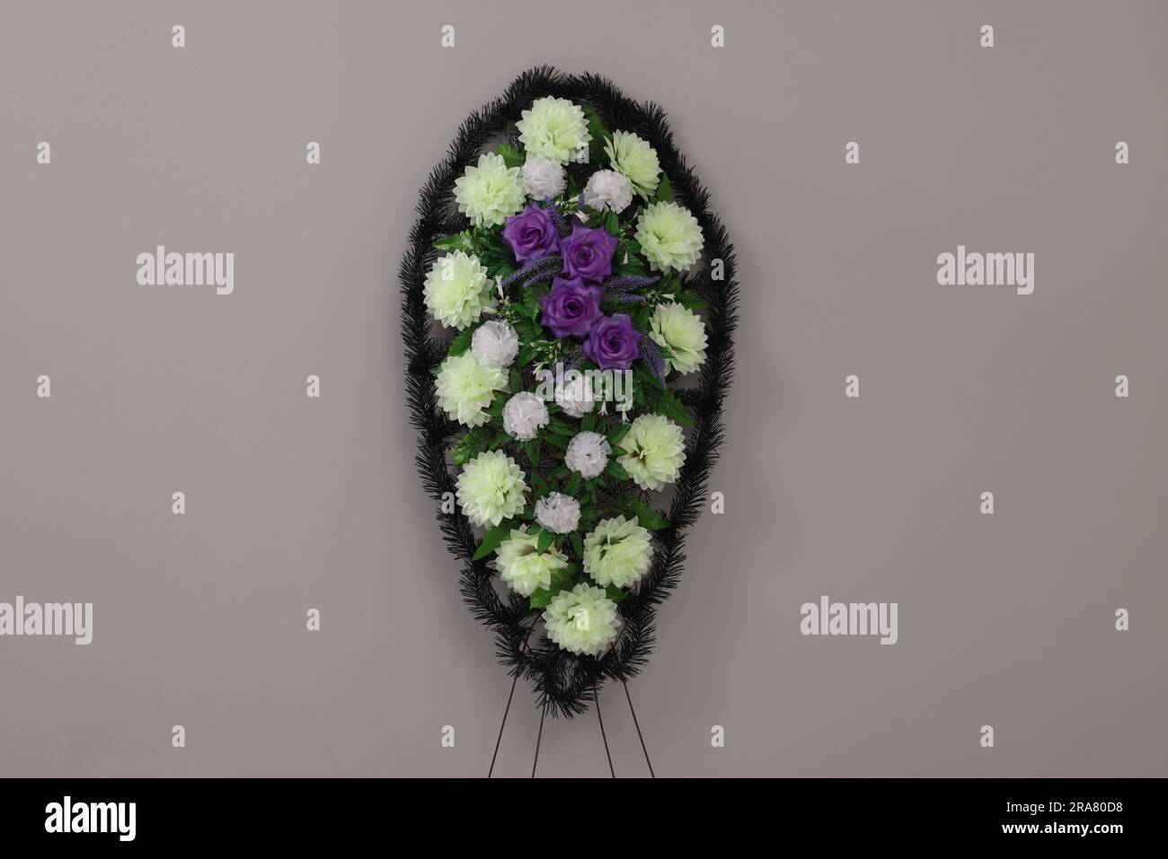 Funeral wreath of plastic flowers on grey background Stock Photo - Alamy