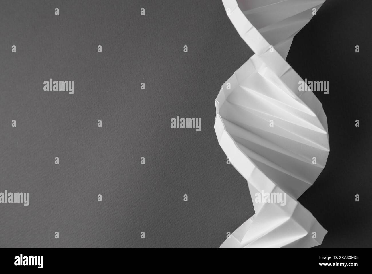 Paper model of DNA molecular chain on black background, top view. Space ...