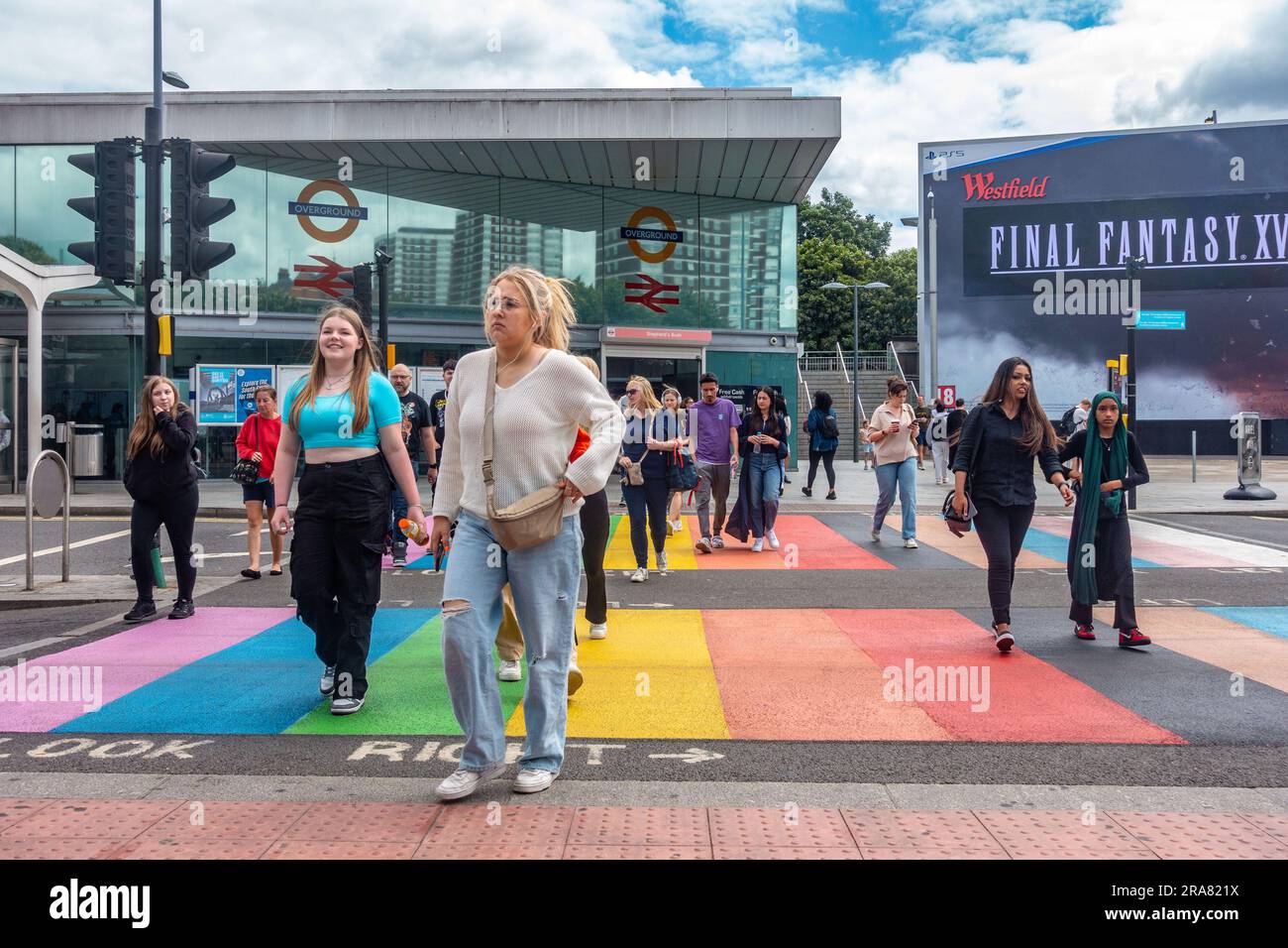 People cross the road via a colourful pedestrian crossing painted in ...