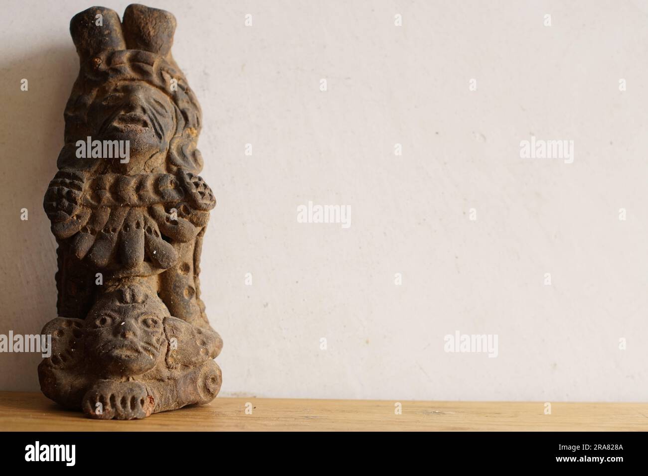 Mayan god clay statues on wooden and white background with copy text ...