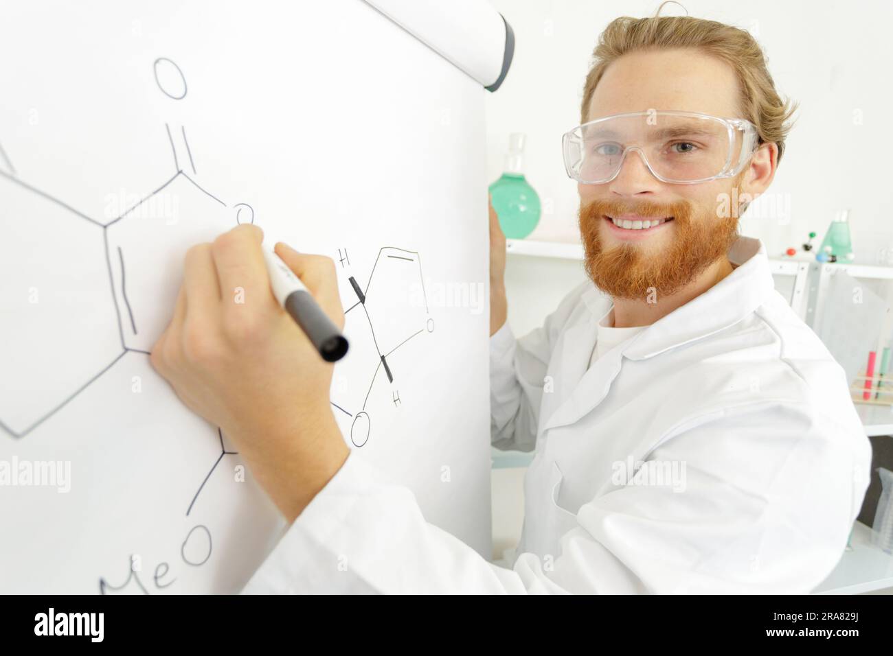 young scientist writing a formula on board Stock Photo - Alamy
