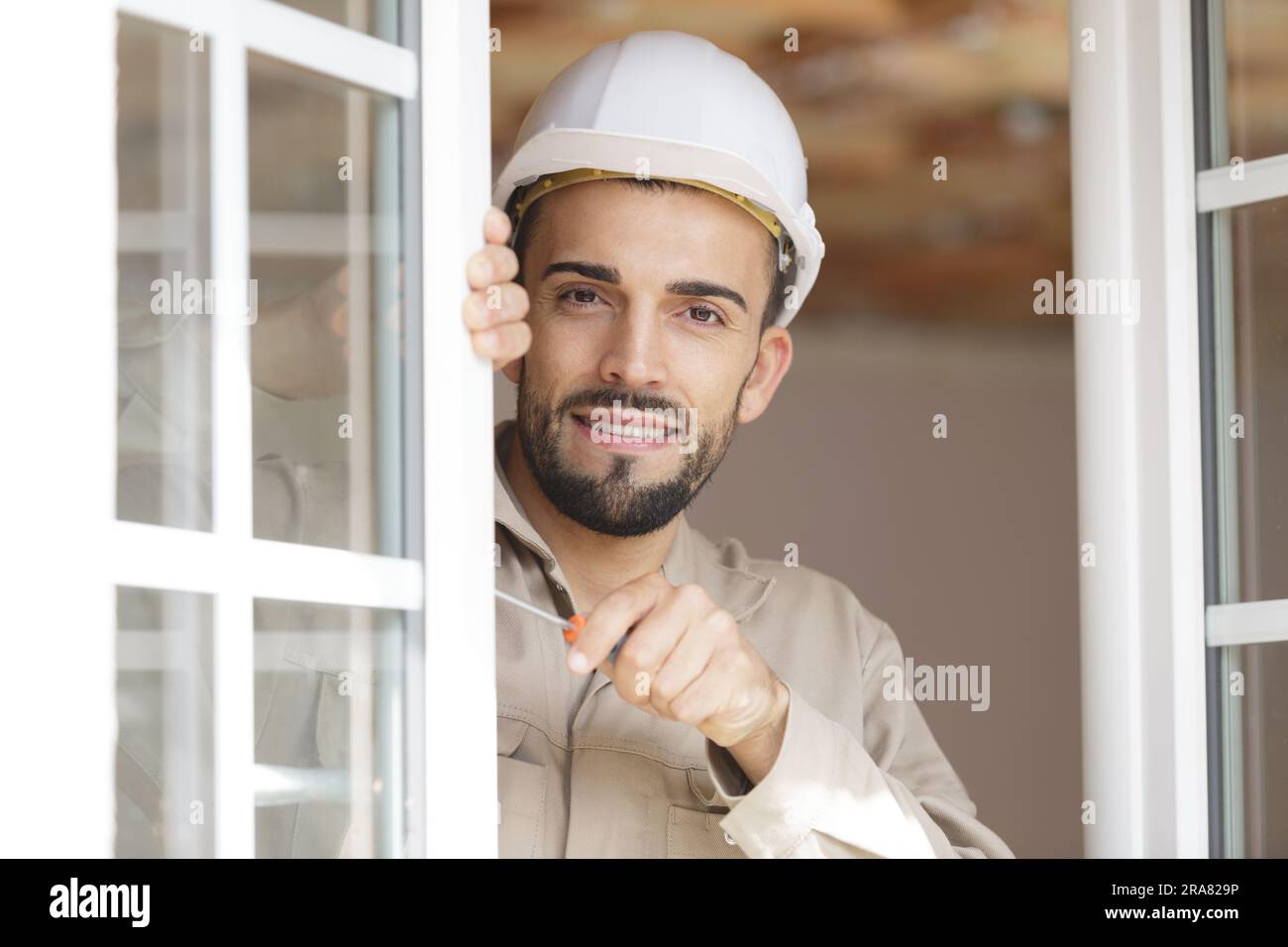 portrait of window fitter using screwdriver Stock Photo - Alamy