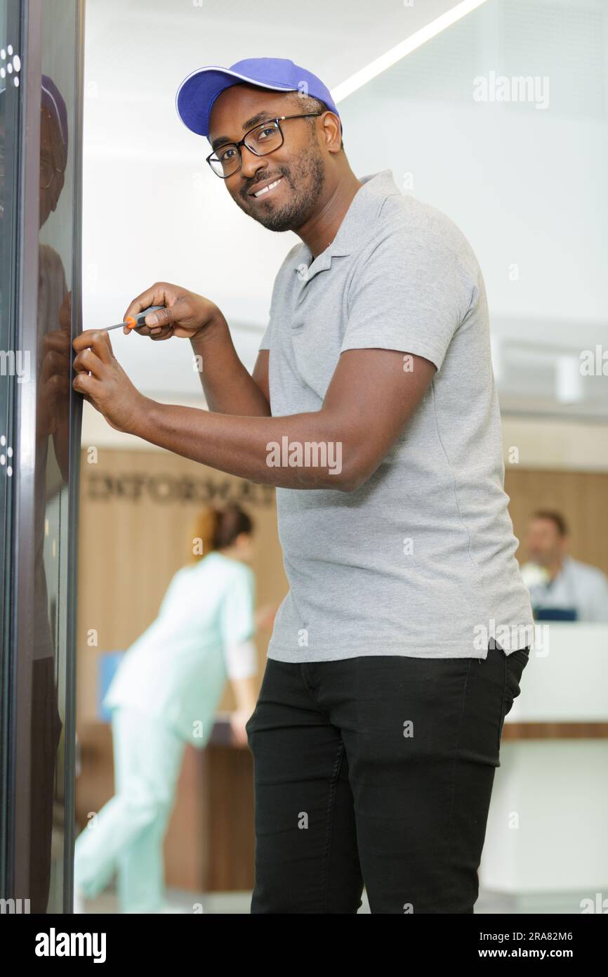 maintenance man in hospital using screwdriver Stock Photo - Alamy