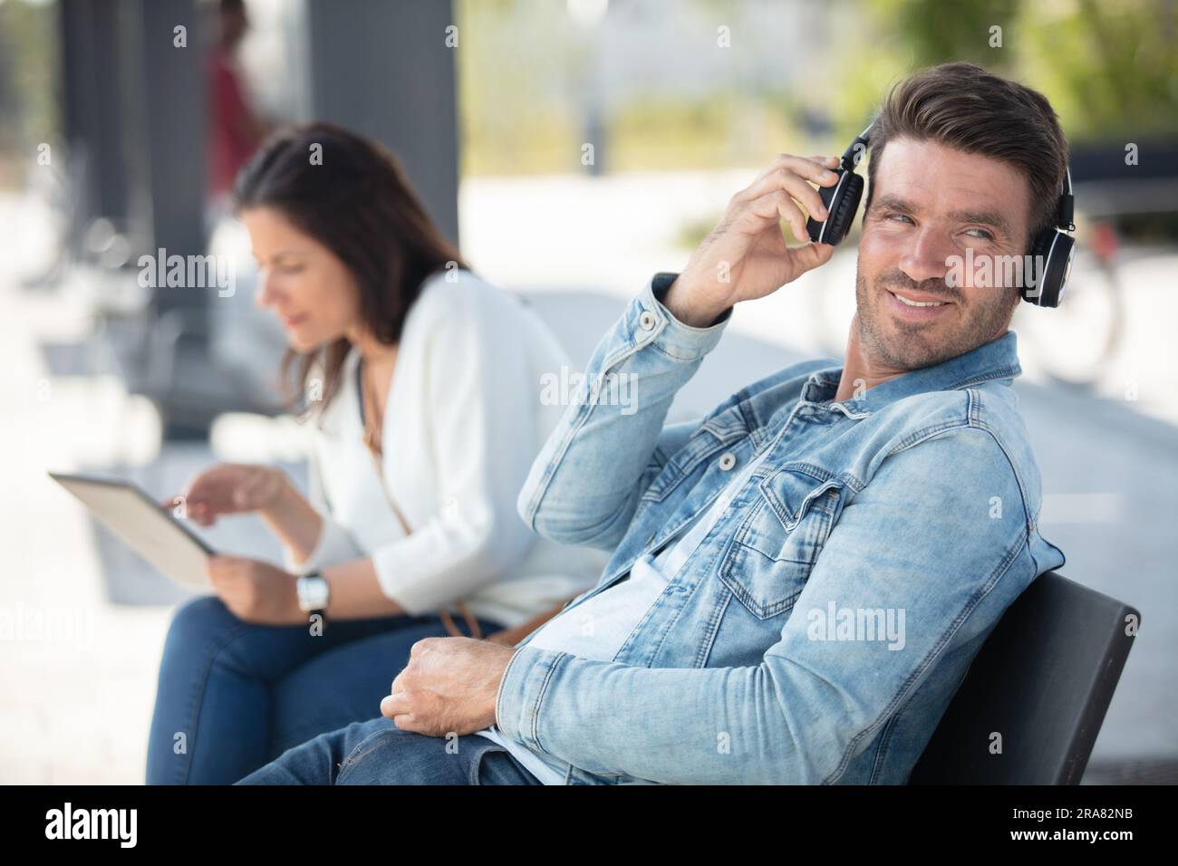 two people chatting at the bus stop Stock Photo - Alamy