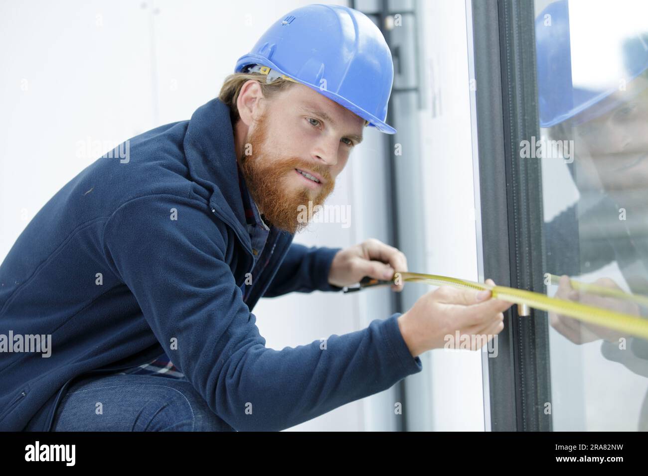 service men measuring window for installation indoors Stock Photo - Alamy