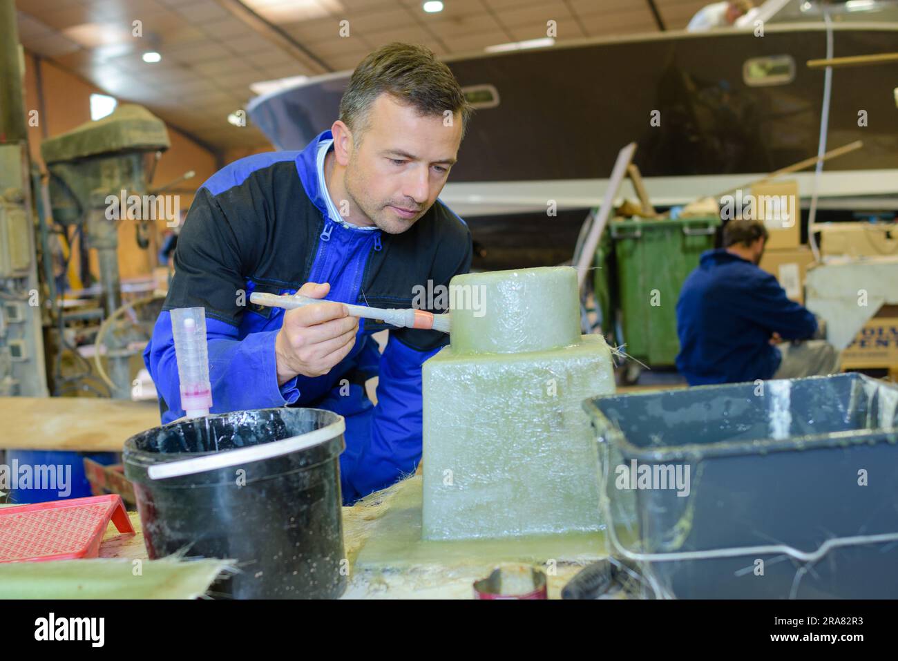 boatmaker painting fibreglass structure in factory Stock Photo - Alamy