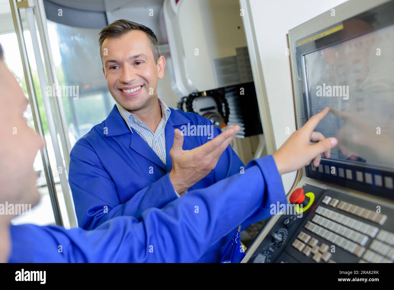 Two men pointing to computer screen and laughing Stock Photo - Alamy