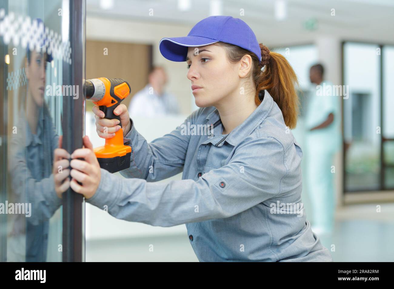 Young woman using drill machine hi-res stock photography and images - Alamy