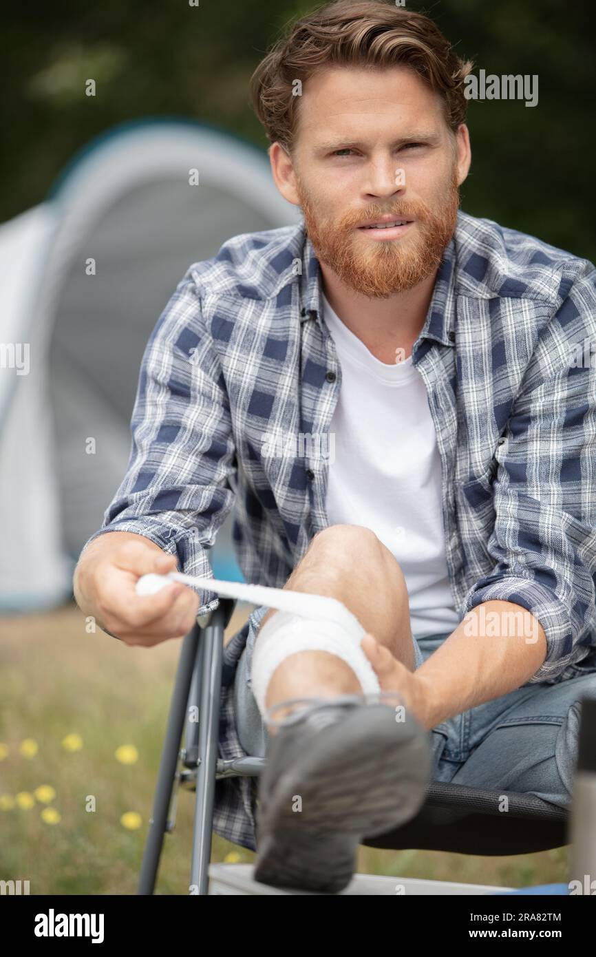 male camper bandaging a leg injury Stock Photo - Alamy