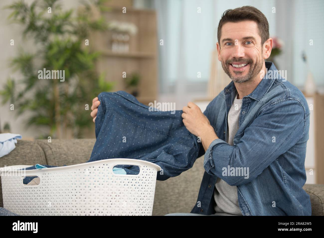 happy man washing clothes at home Stock Photo - Alamy