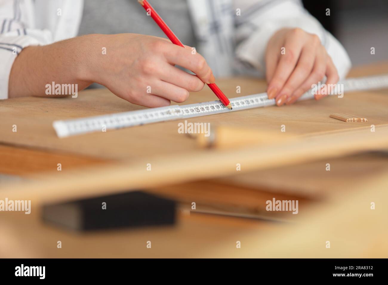 craftsman measuring wooden plank with ruler Stock Photo - Alamy