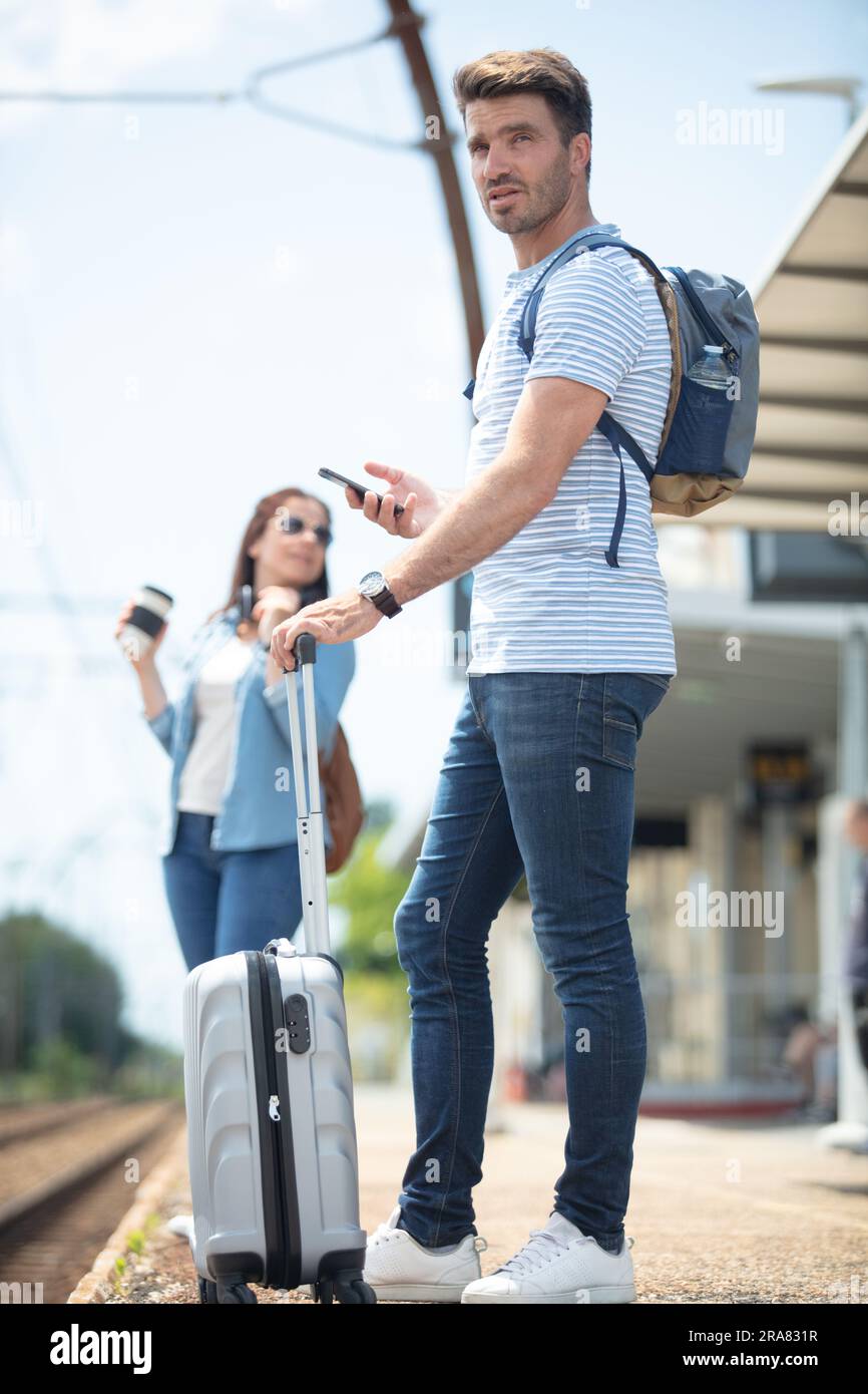 man waiting for the train on railway station platform Stock Photo - Alamy