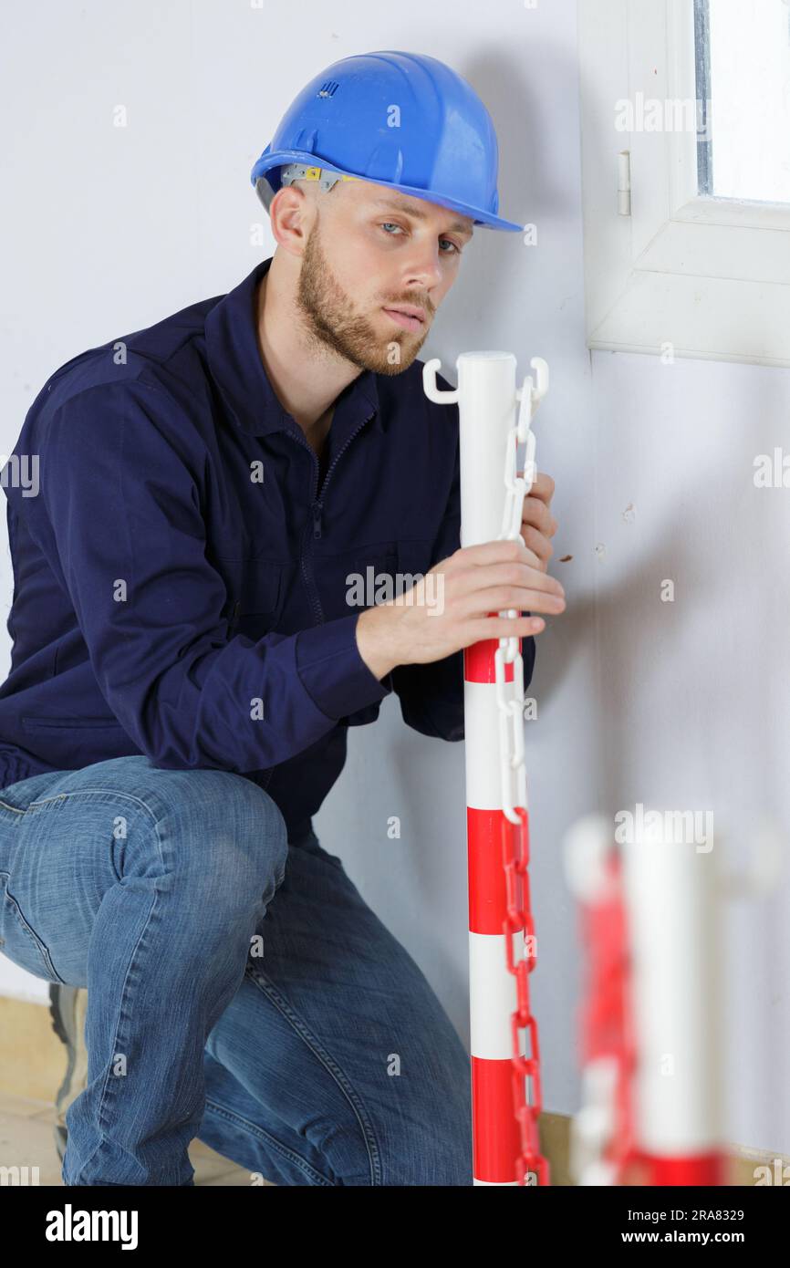 male builder installing chains in construction site Stock Photo - Alamy