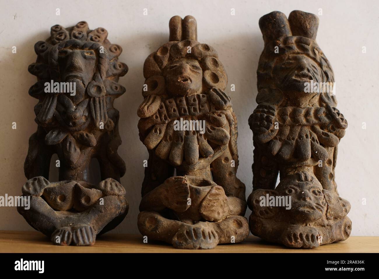 Mayan god clay statues on wooden and white background with copy text ...