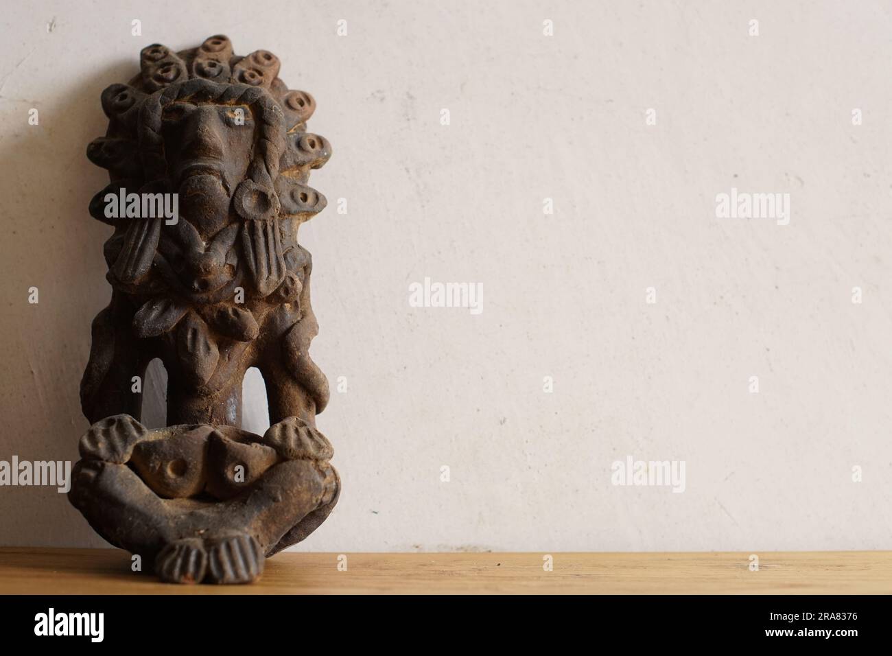 Mayan god clay statues on wooden and white background with copy text ...