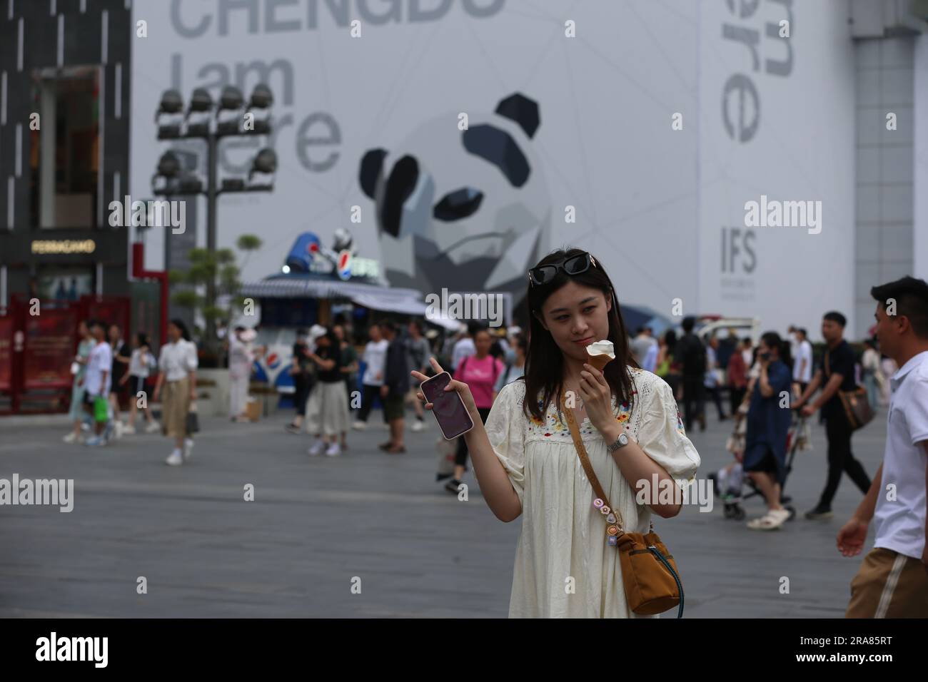 CHENGDE, CHINA - JUNE 29, 2023 - A girl eats ice cream with a panda ...