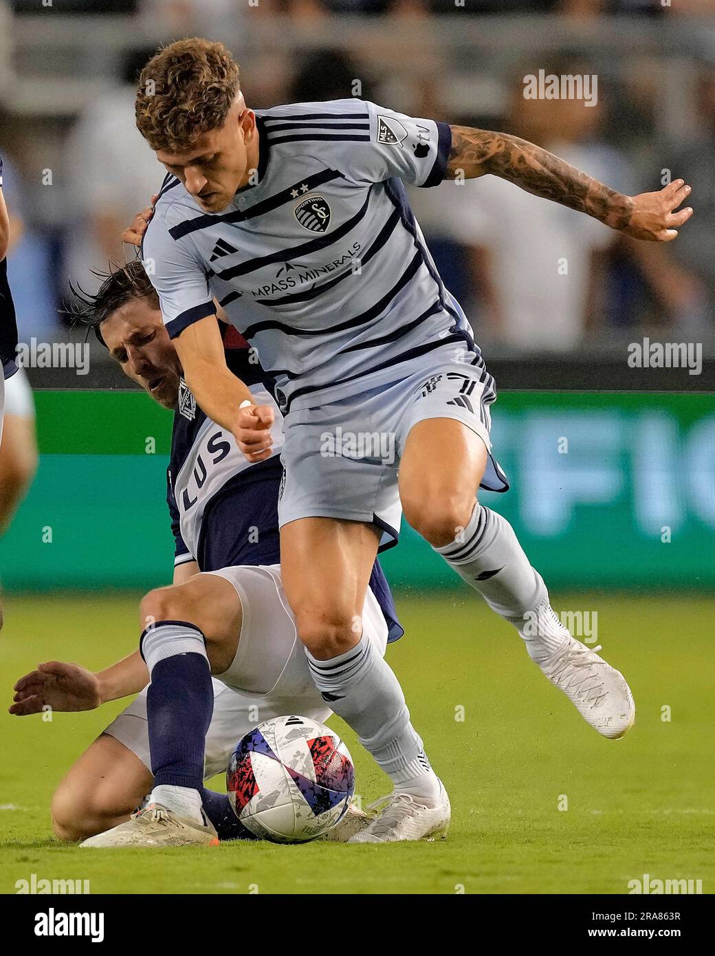 Sporting Kansas City forward Marinos Tzionis, front, and Vancouver Whitecaps midfielder Ryan ...