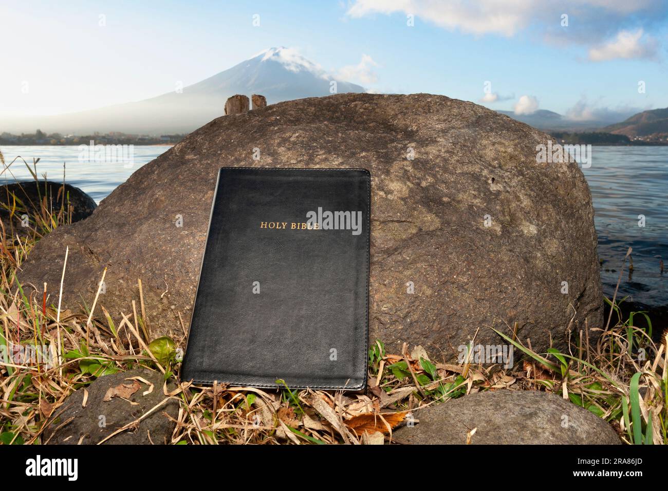 Holy Bible leaning against a rock on the shore of Lake Kawaguchi with ...
