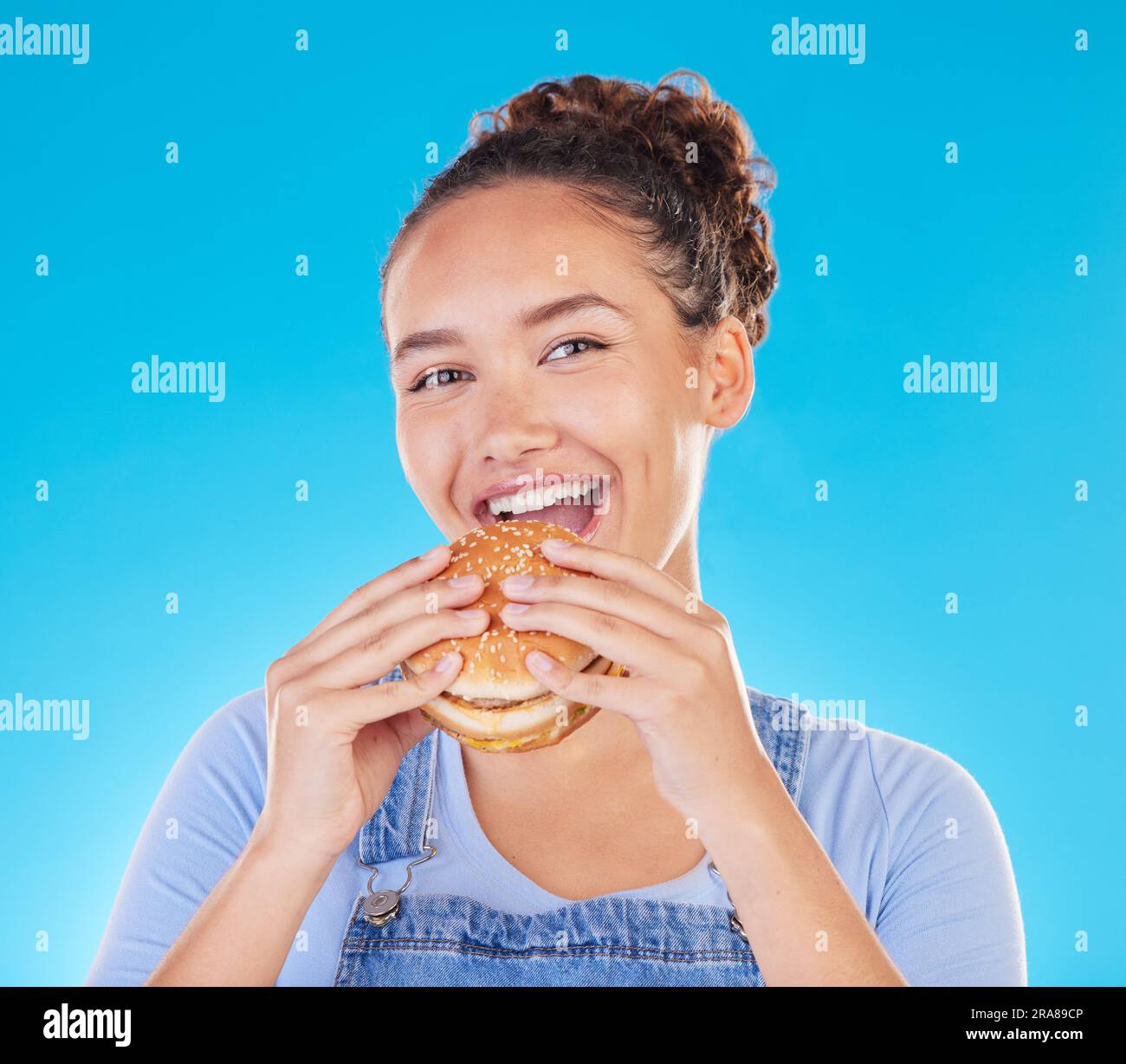 Burger, smile and woman eating fast food and happy with lunch meal with ...