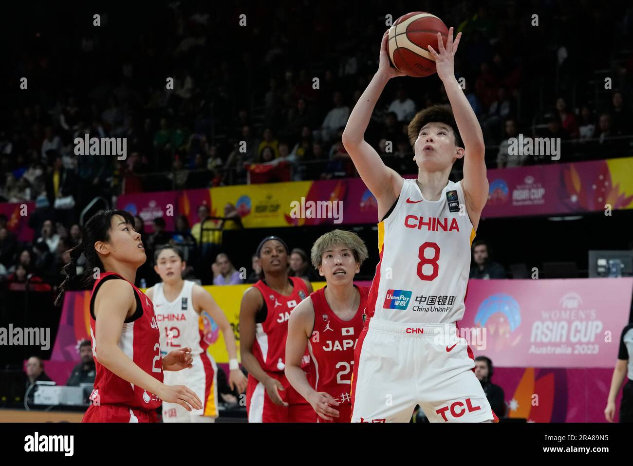 China's Jin Weina, right, takes a shot at goal as Japan's Mai Yamamoto ...