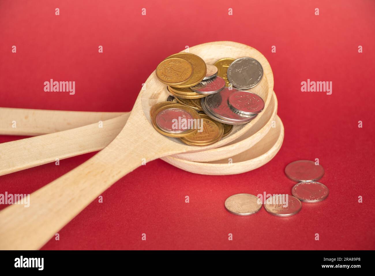 wooden spoon with pennies on a red background close up Stock Photo - Alamy