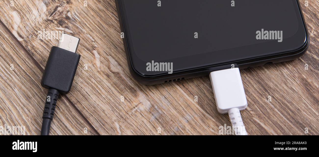 Smartphone with charger cables. Mobile phone charging concept Stock ...