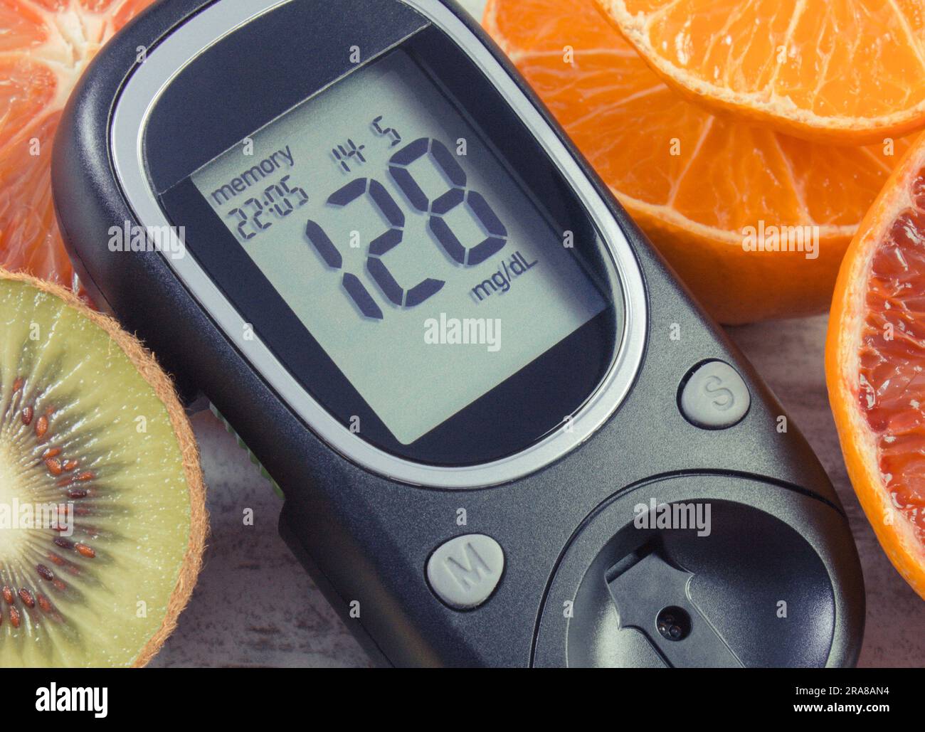 Glucose meter with result of sugar level and fresh natural fruits ...