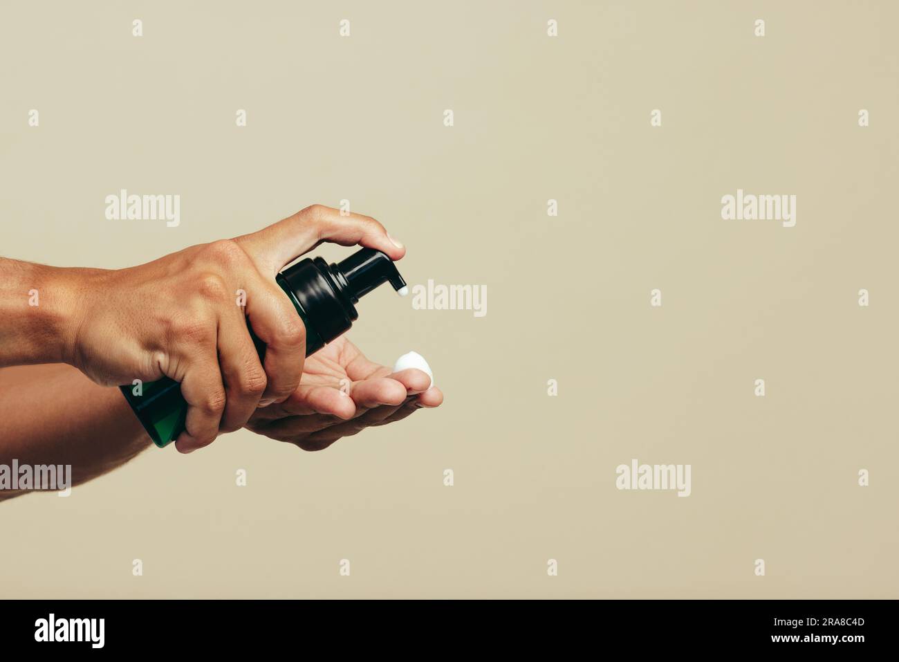 Man carefully applies face wash to his hands, dispensing the right ...
