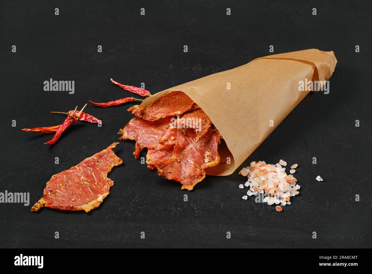 Dried pork jerky slices in parchment paper bag with salt and chilli ...