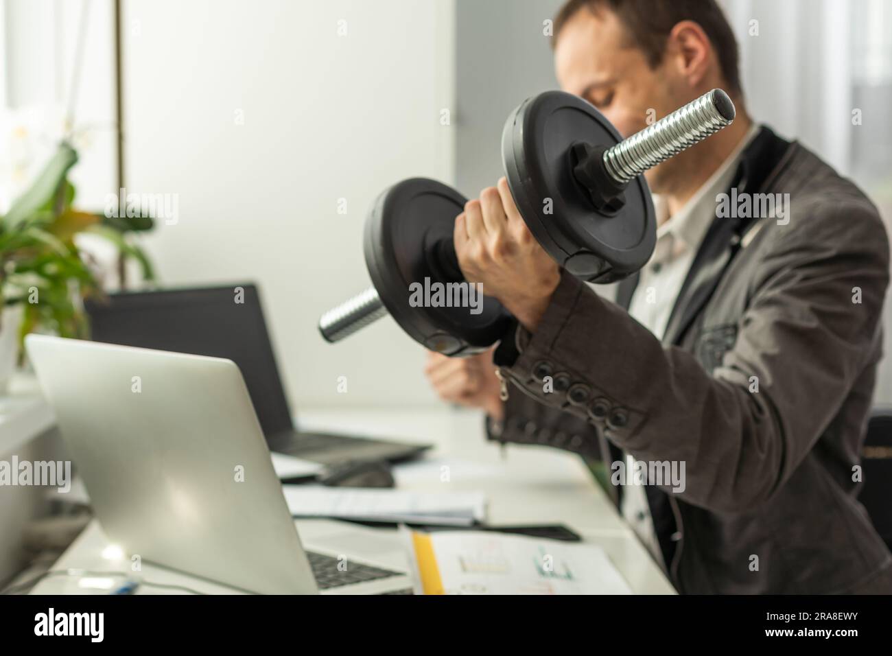 Businessman Doing Exercise With Dumbbell Stock Photo - Alamy