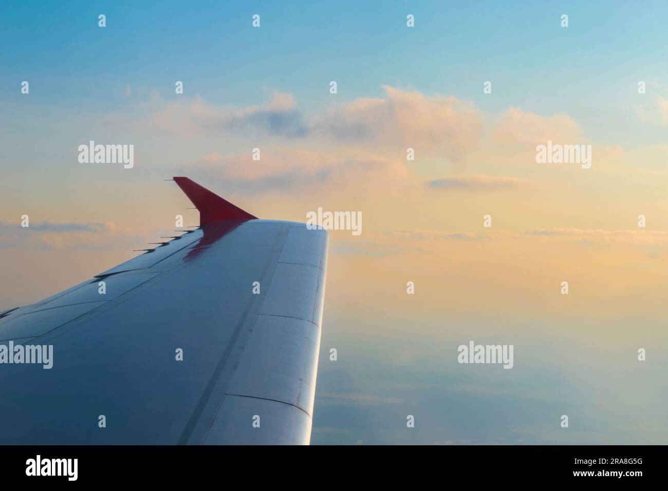 A captivating aerial perspective of a wing aircraft soaring through the sky. The vibrant red ...