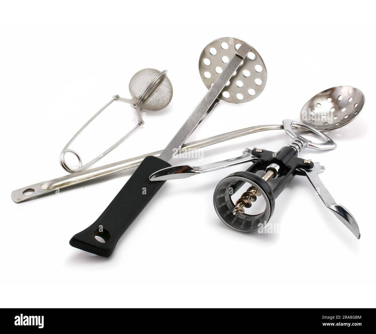 Two perforated spoons, tea strainer and corkscrew isolated on a white ...