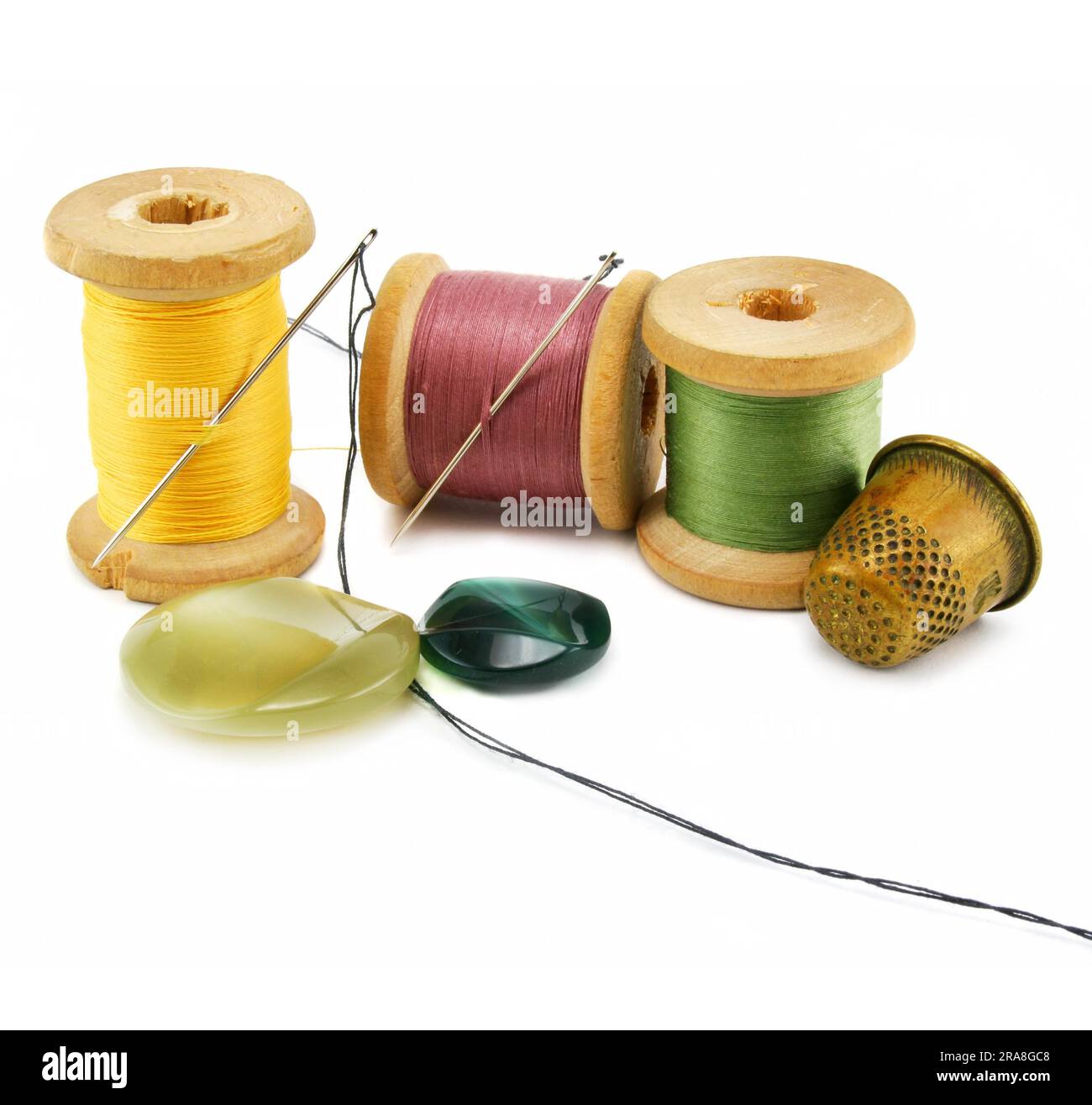 Spool of thread, thimble and needle isolated on a white background ...