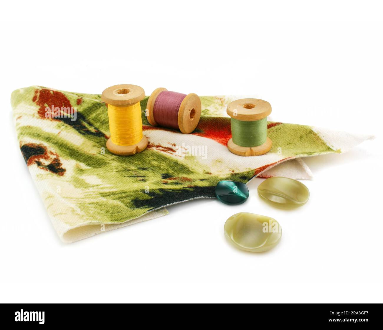 Piece of cloth, colored threads and buttons isolated on a white ...
