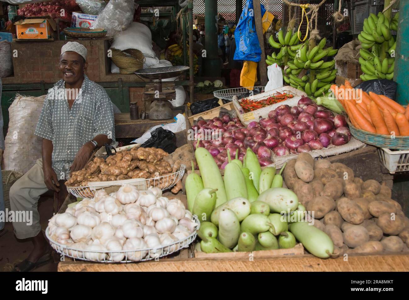 Vendor at market stall with vegetables, vegetable market, Mombasa ...