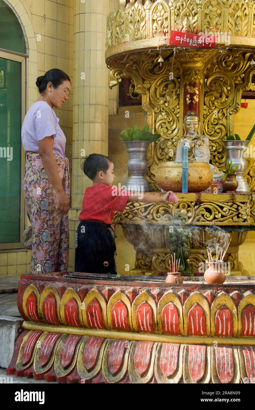 Child pours holy water on Buddha, Sule Pagoda, Yangon, Burma, Myanmar ...