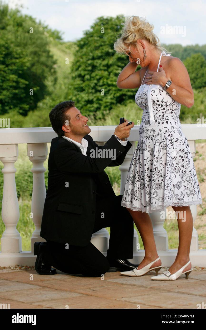 Man proposes to woman, on knees, eye contact, kneeling Stock Photo - Alamy