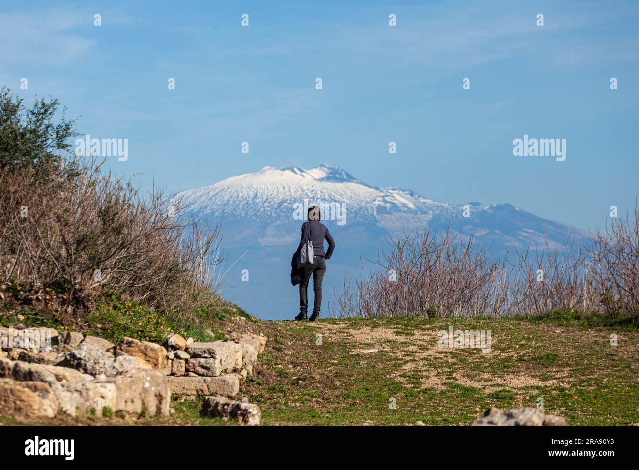 A tourist watch the Etna volcano from Morgantina, Sicily Stock Photo ...