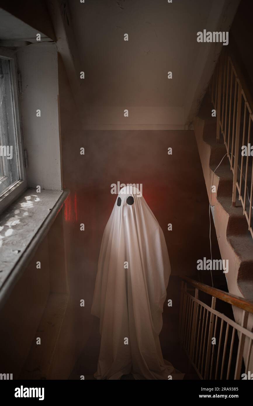 Inside of old creepy abandoned mansion. Ghost in sheet climbs up the ...