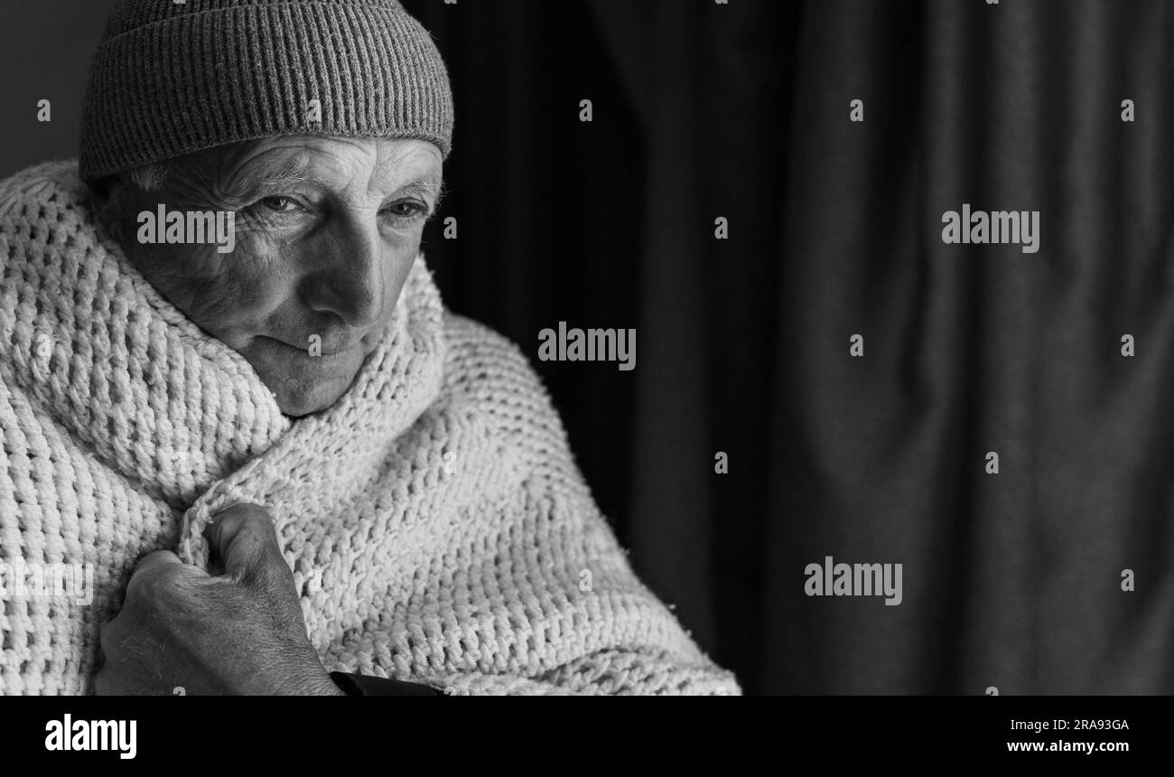 Black and white photo of senior man wrapped in blanket feeling cold at ...